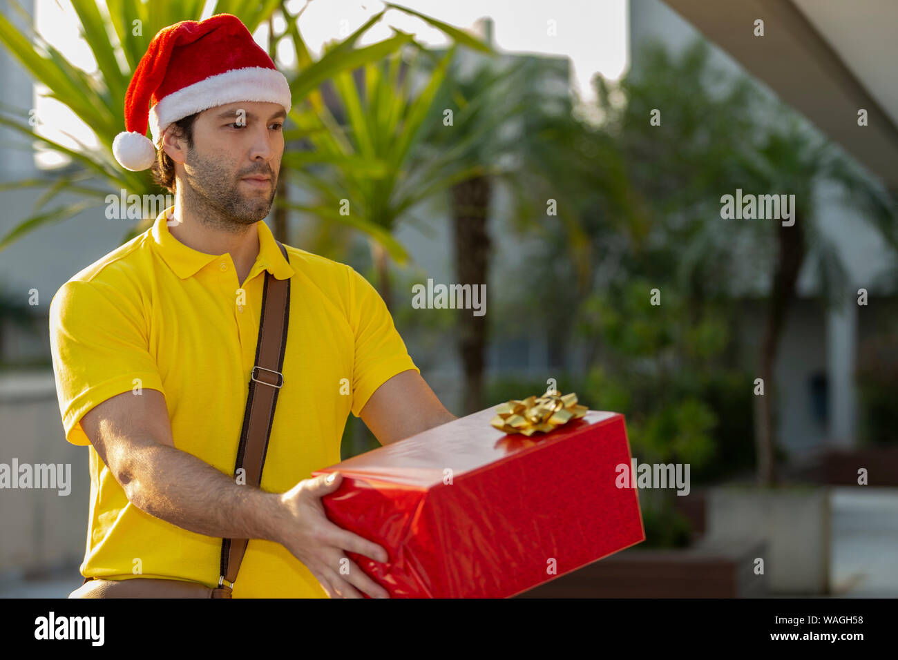 Brazilian mailman dressed as Santa Claus delivering a gift. Online ...