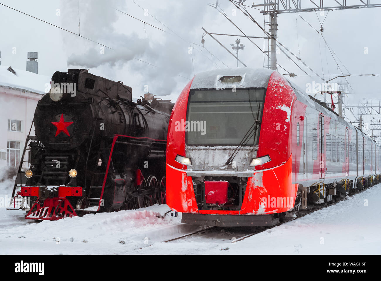 steam locomotive and modern electric multiple-unit train stand nearby ...