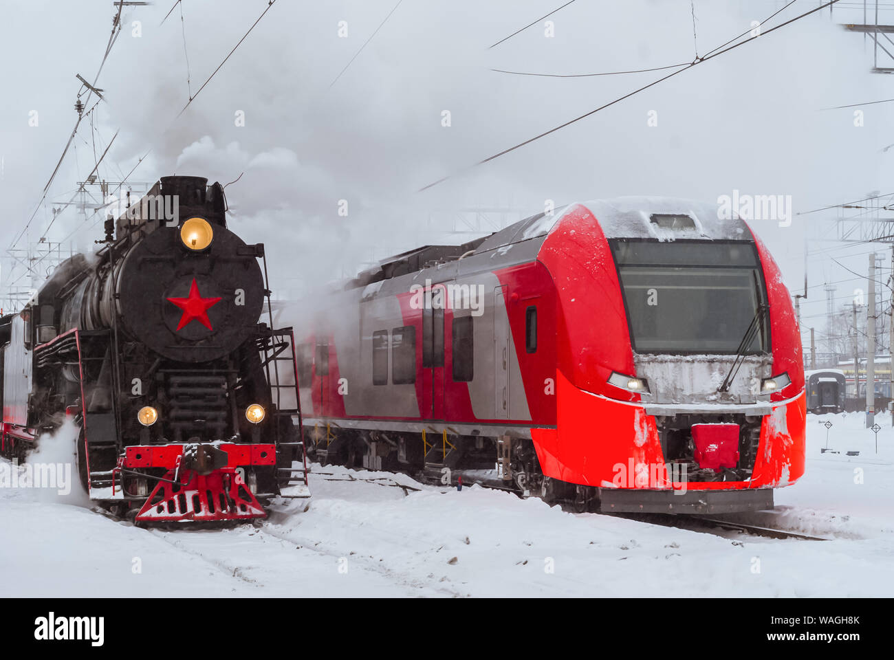 steam locomotive and modern electric multiple-unit train stand nearby ...