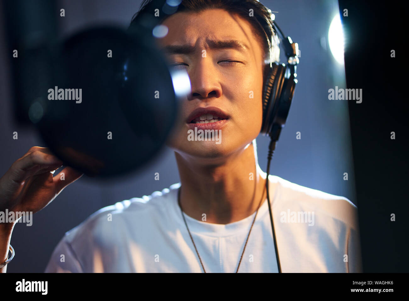 young asian adult man enjoying singing a song in modern recording studio Stock Photo - Alamy