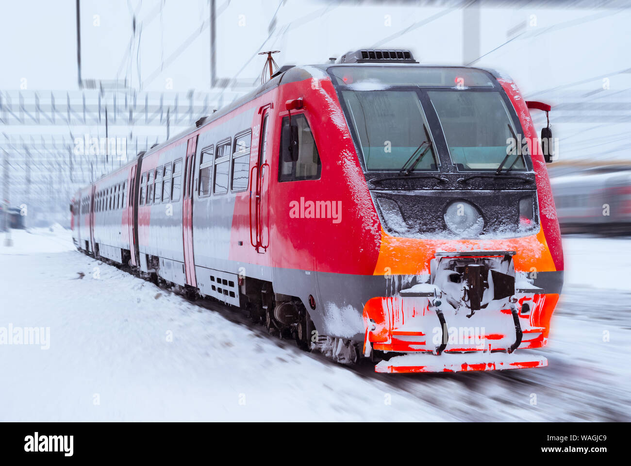 ice-covered diesel multiple unit train rushes along a blurred winter railway landscape Stock ...