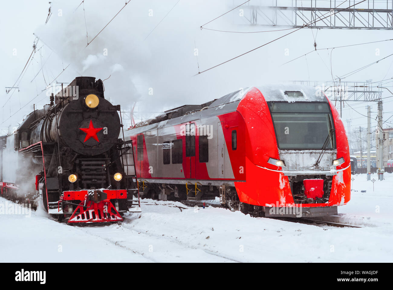 steam locomotive and modern electric multiple-unit train stand nearby ...