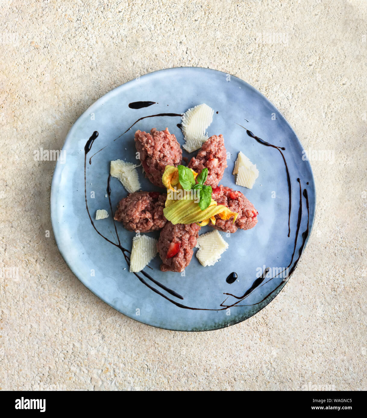 Artistic dish with raw meat cheese and vegetables laid on a luxurious ...