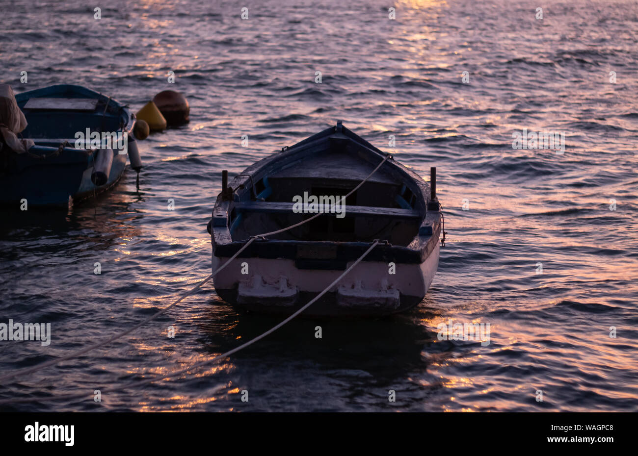 Two small boats floating in the sea at sunset Stock Photo - Alamy