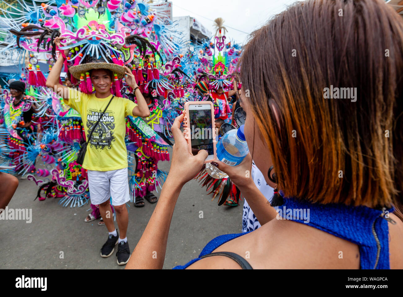 A Young Woman Takes A Photo Of A Colourful Procession During The Ati ...