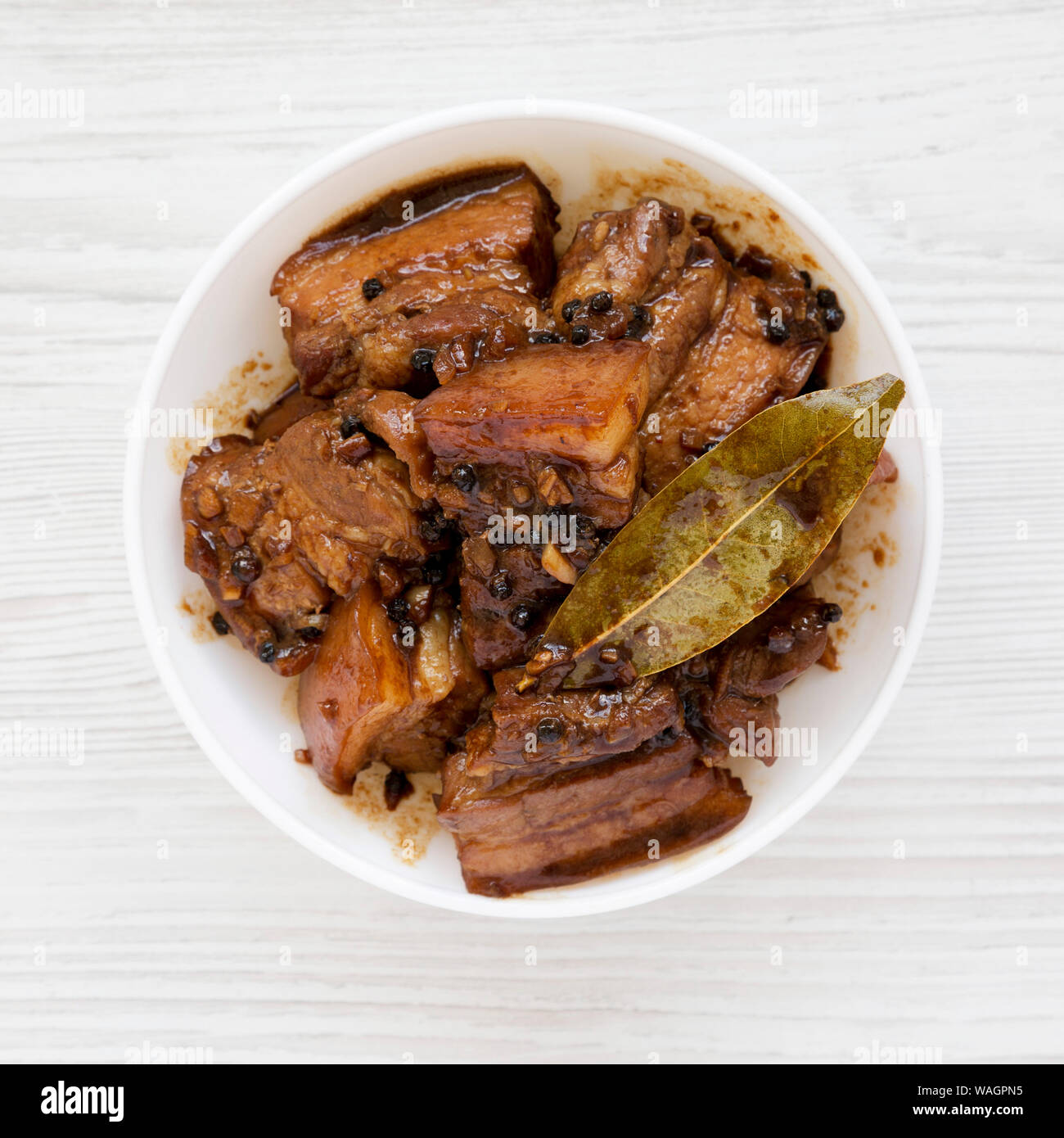 Homemade Filipino Adobo Pork on a white wooden surface, overhead view ...