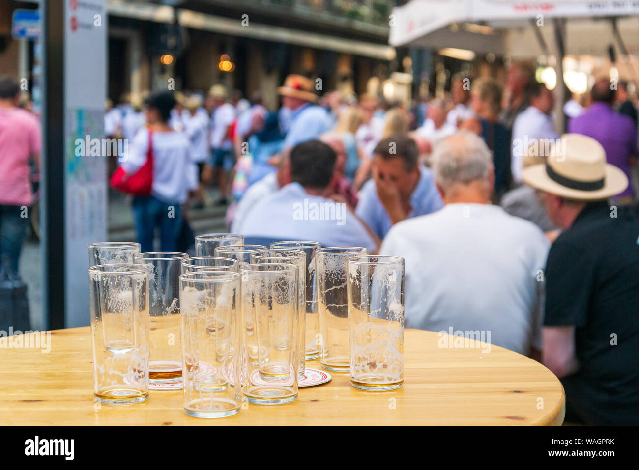 Empty glasses of beer on wooden table beside walking street, and blur ...