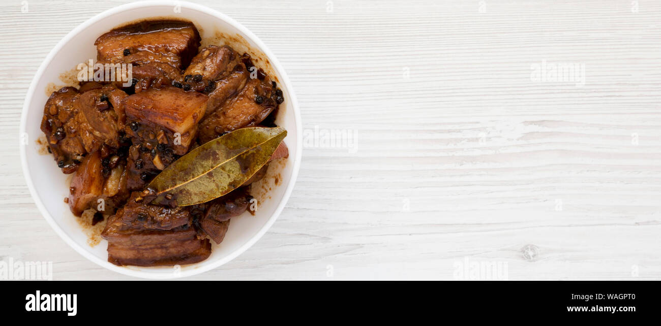Homemade Filipino Adobo Pork in a white bowl over white wooden ...