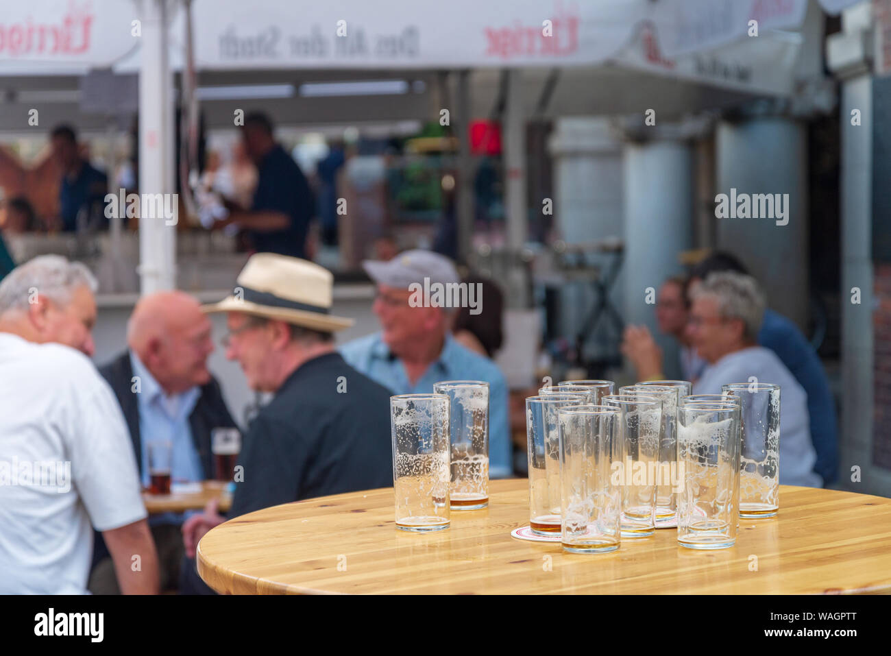 Empty glasses of beer on wooden table beside walking street, and blur ...