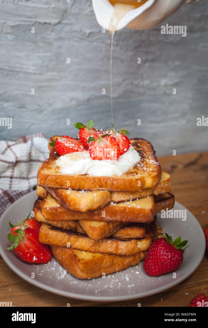 French toast with fresh strawberries, coconut shreds and dripping honey ...