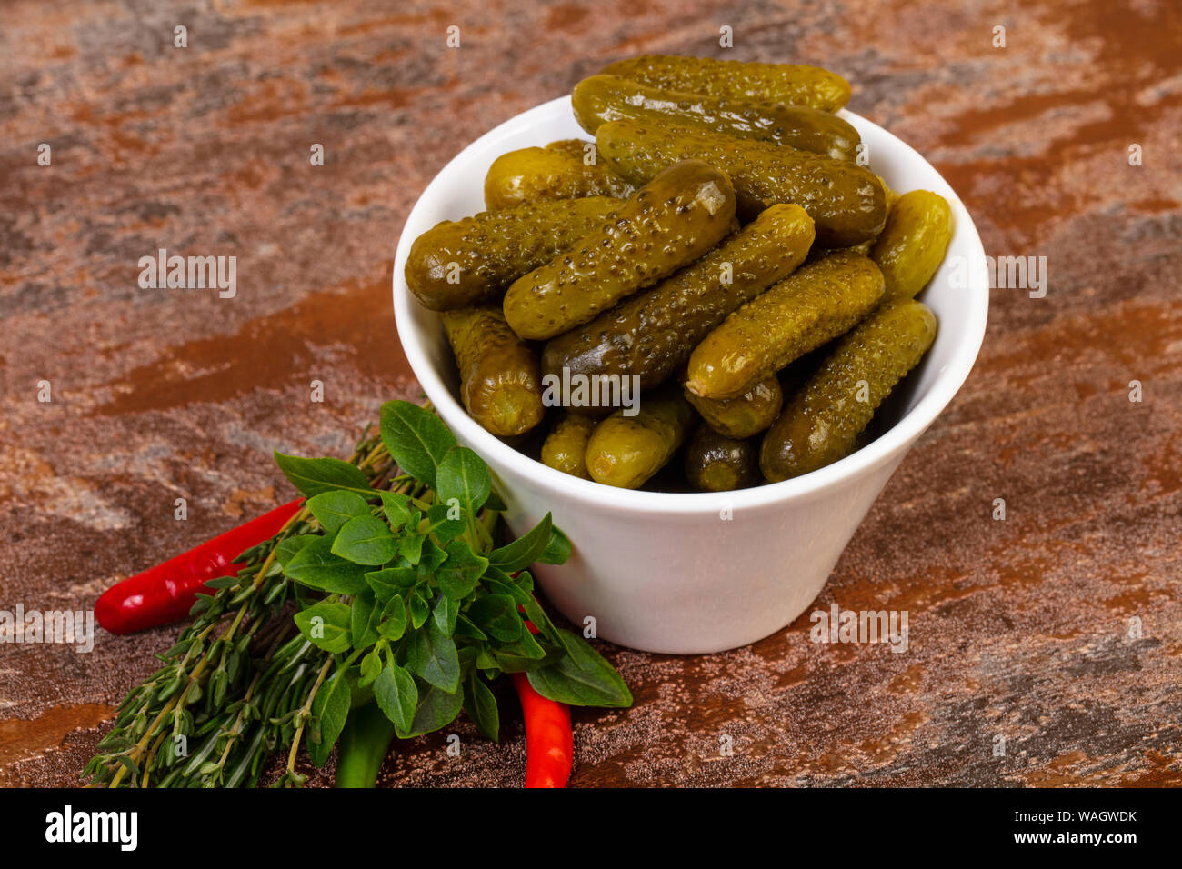 Pickled small cucumbers in the bowl served herbs Stock Photo - Alamy