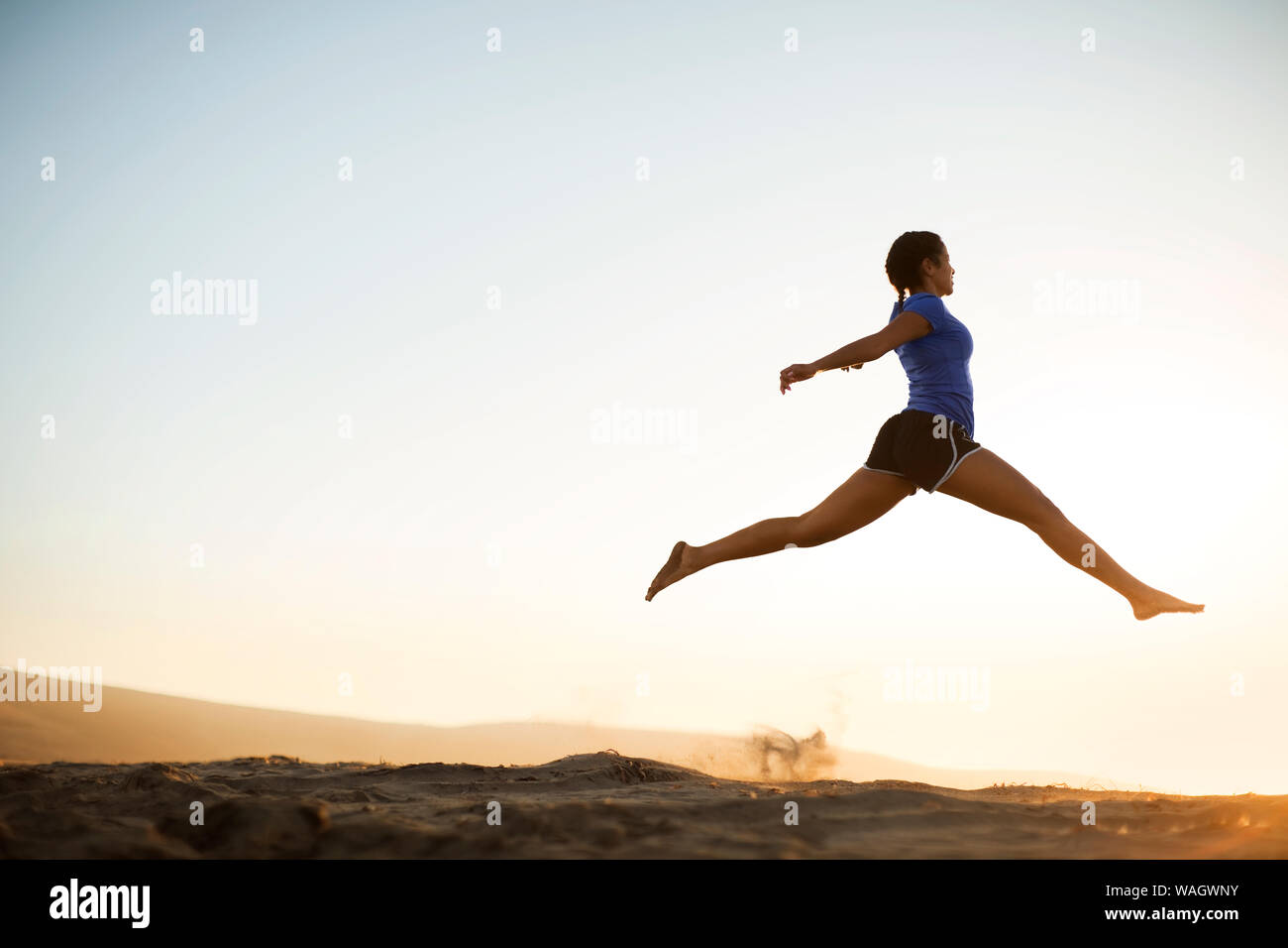Young woman leaping at the beach Stock Photo - Alamy