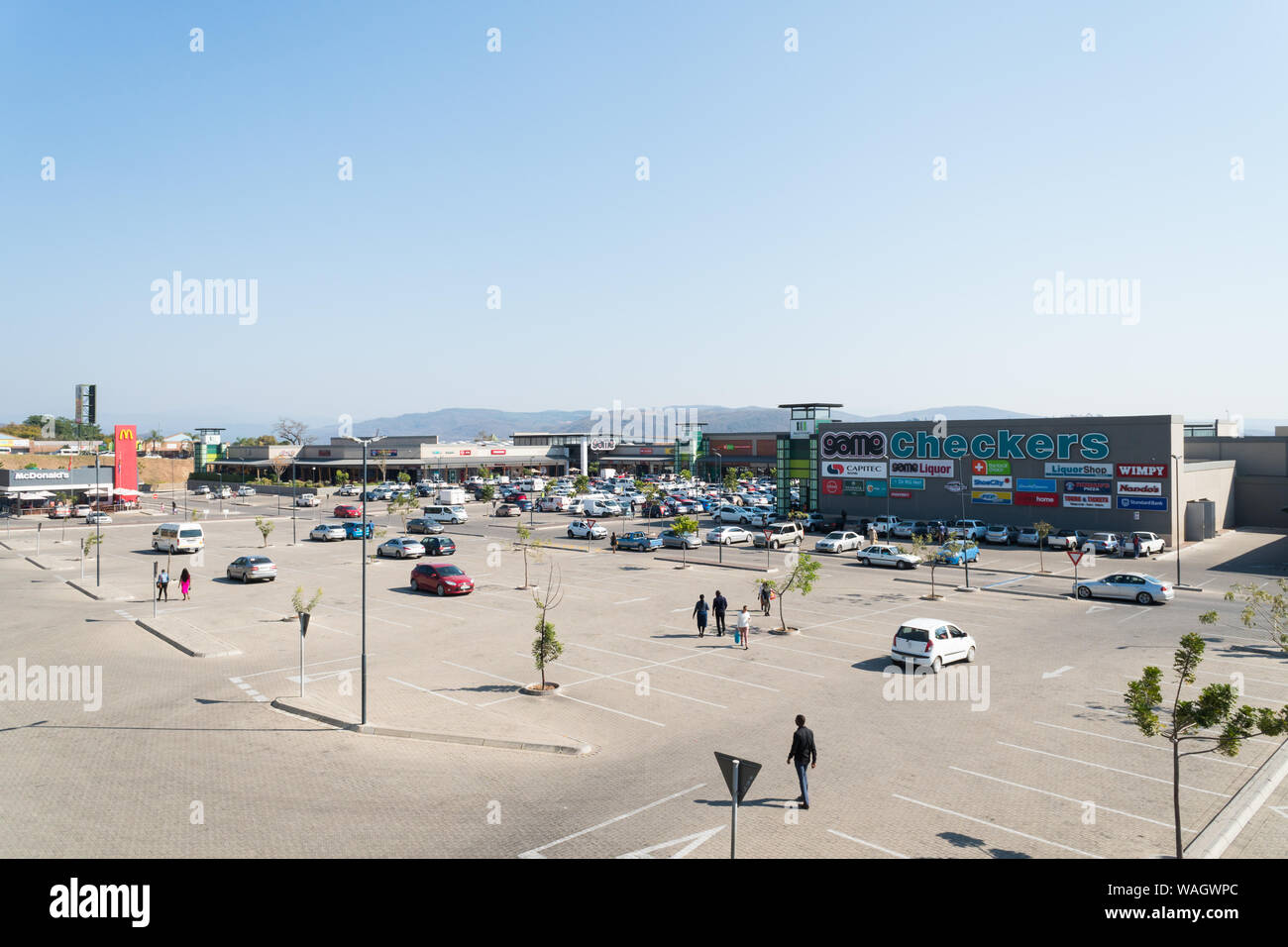 aerial view or view from above onto a parking lot at shopping centre or ...