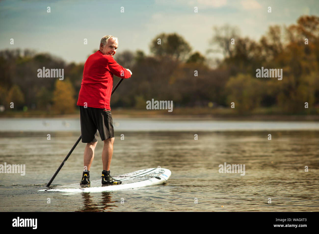 Senior man paddle boarding Stock Photo - Alamy