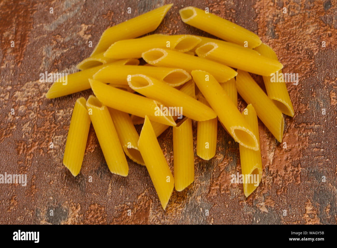 Raw penne pasta ready for bowl Stock Photo - Alamy