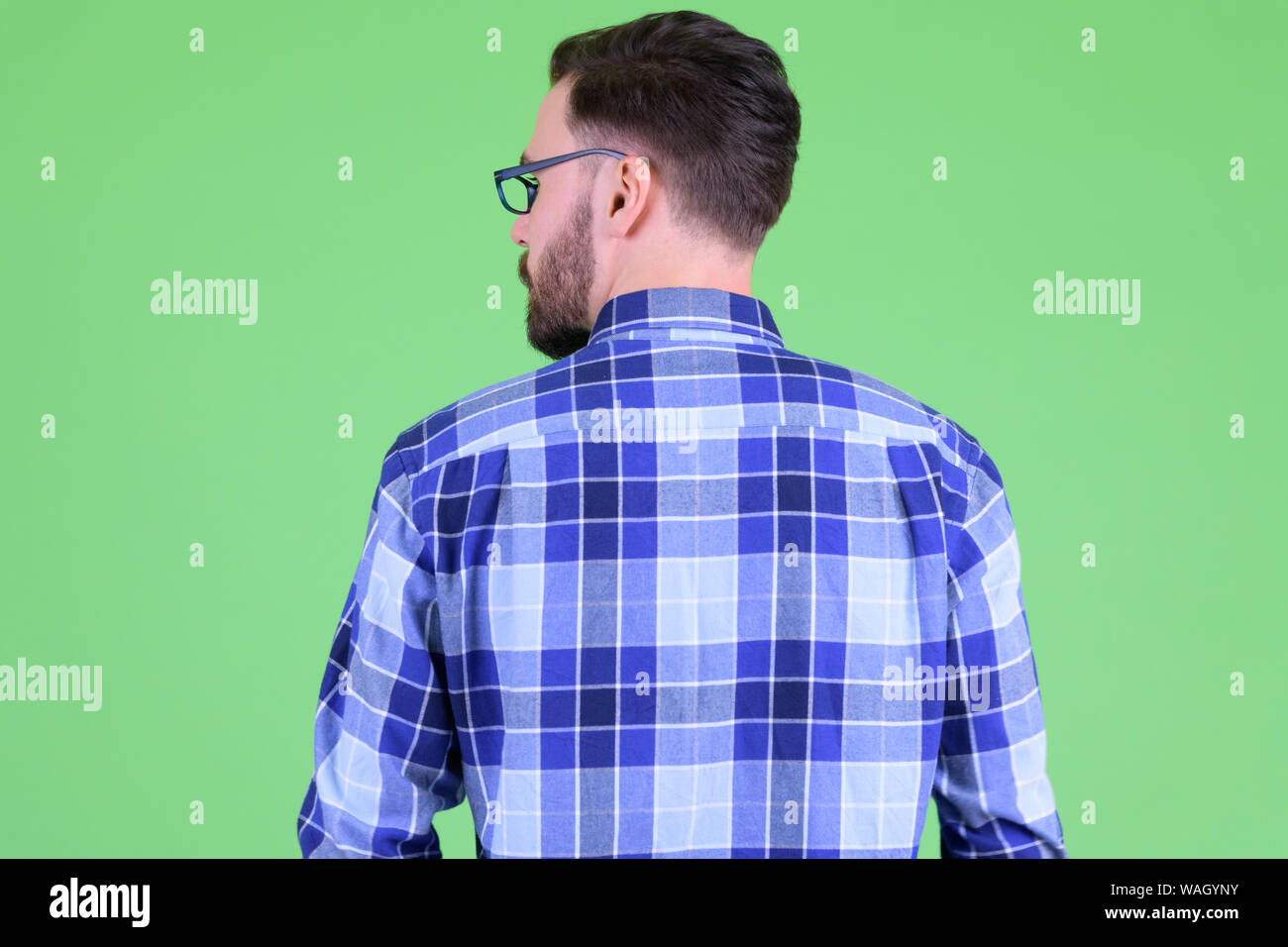 Rear view of young bearded hipster man looking over shoulder Stock ...