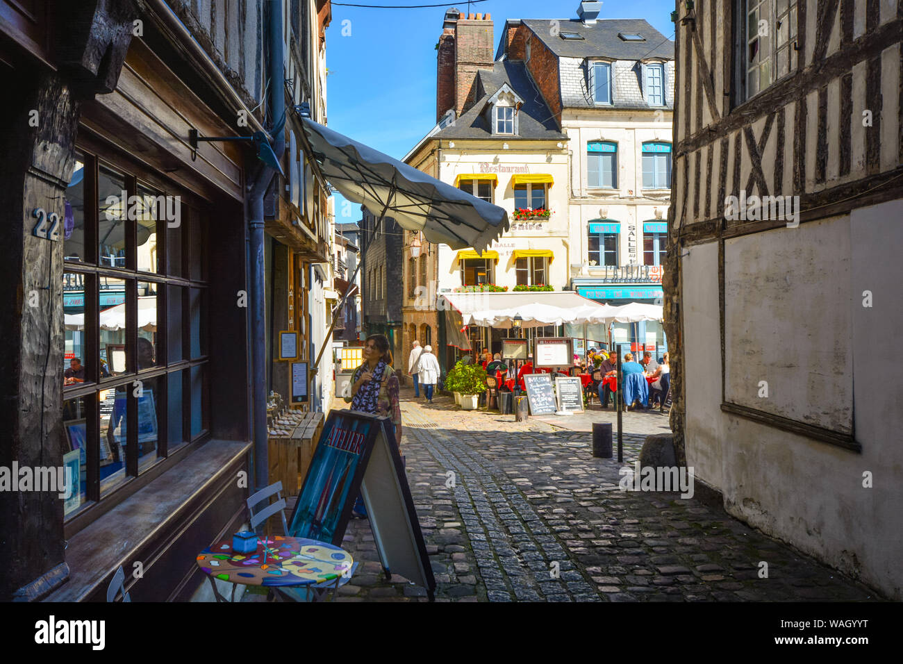 A woman window shops on a sunny day in the Normandy town of Honfleur ...