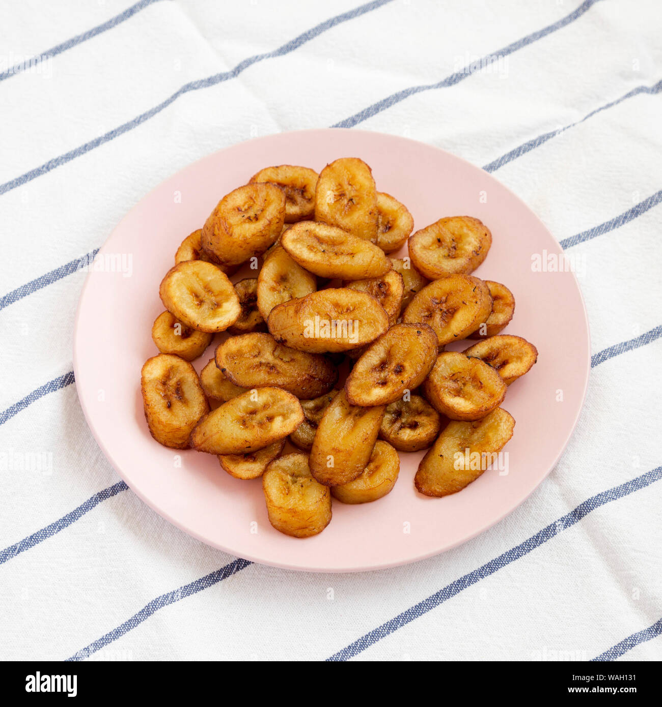 Homemade fried plantains on a pink plate, side view Stock Photo - Alamy