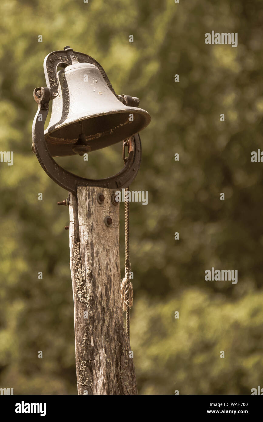 Bell on tall wooden post located between the Smoke House and the ...