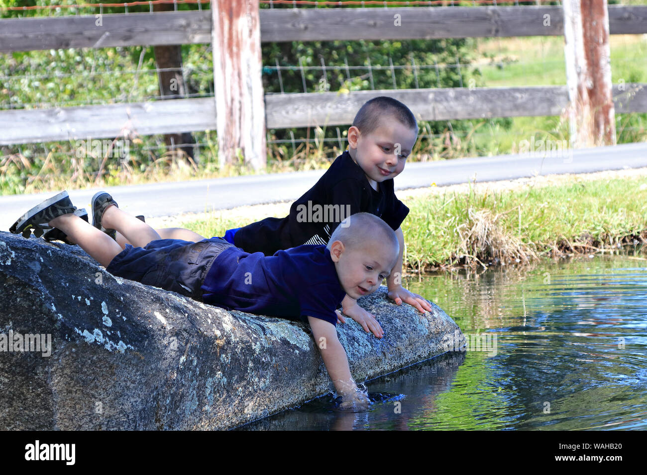 Kids having fun and playing in a rural pond Stock Photo - Alamy