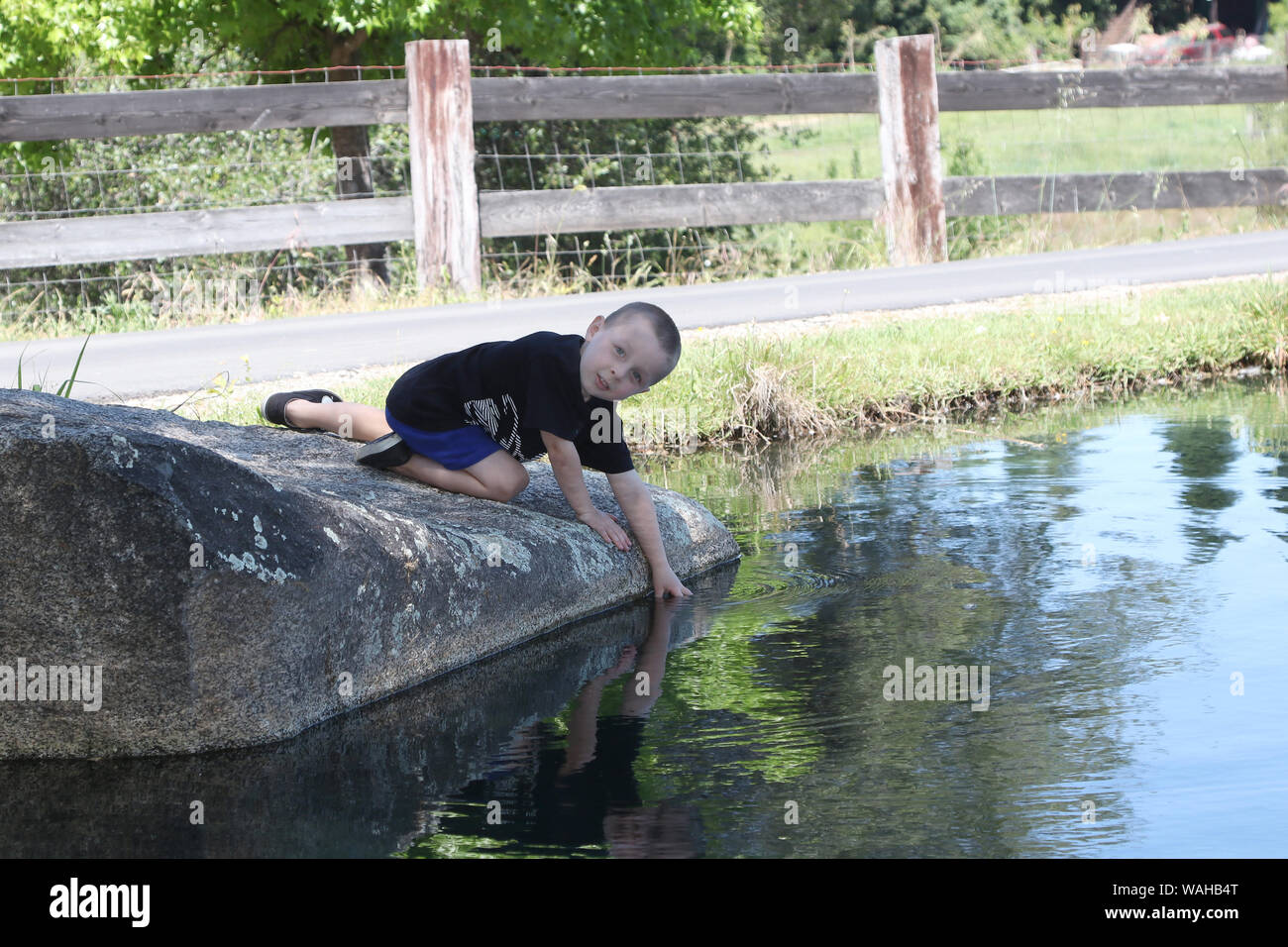 Kids having fun and playing in a rural pond Stock Photo - Alamy