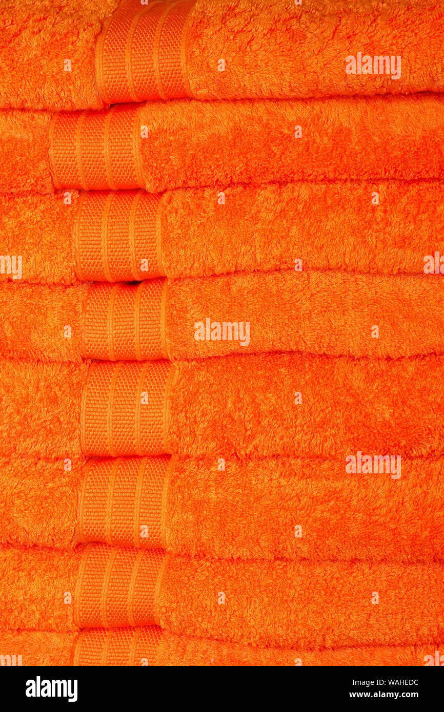 Big pile of soft thick orange towels Stock Photo - Alamy
