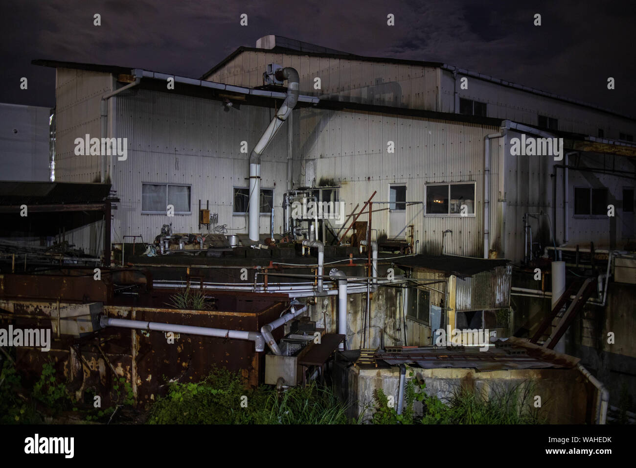 Old rusting factory exterior at night Stock Photo - Alamy
