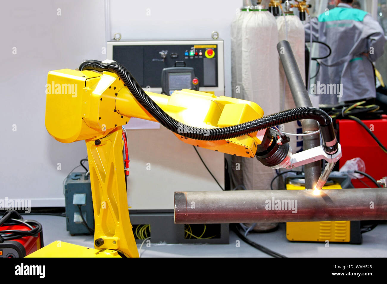 Yellow robotic arm for automatic welding pipes Stock Photo - Alamy