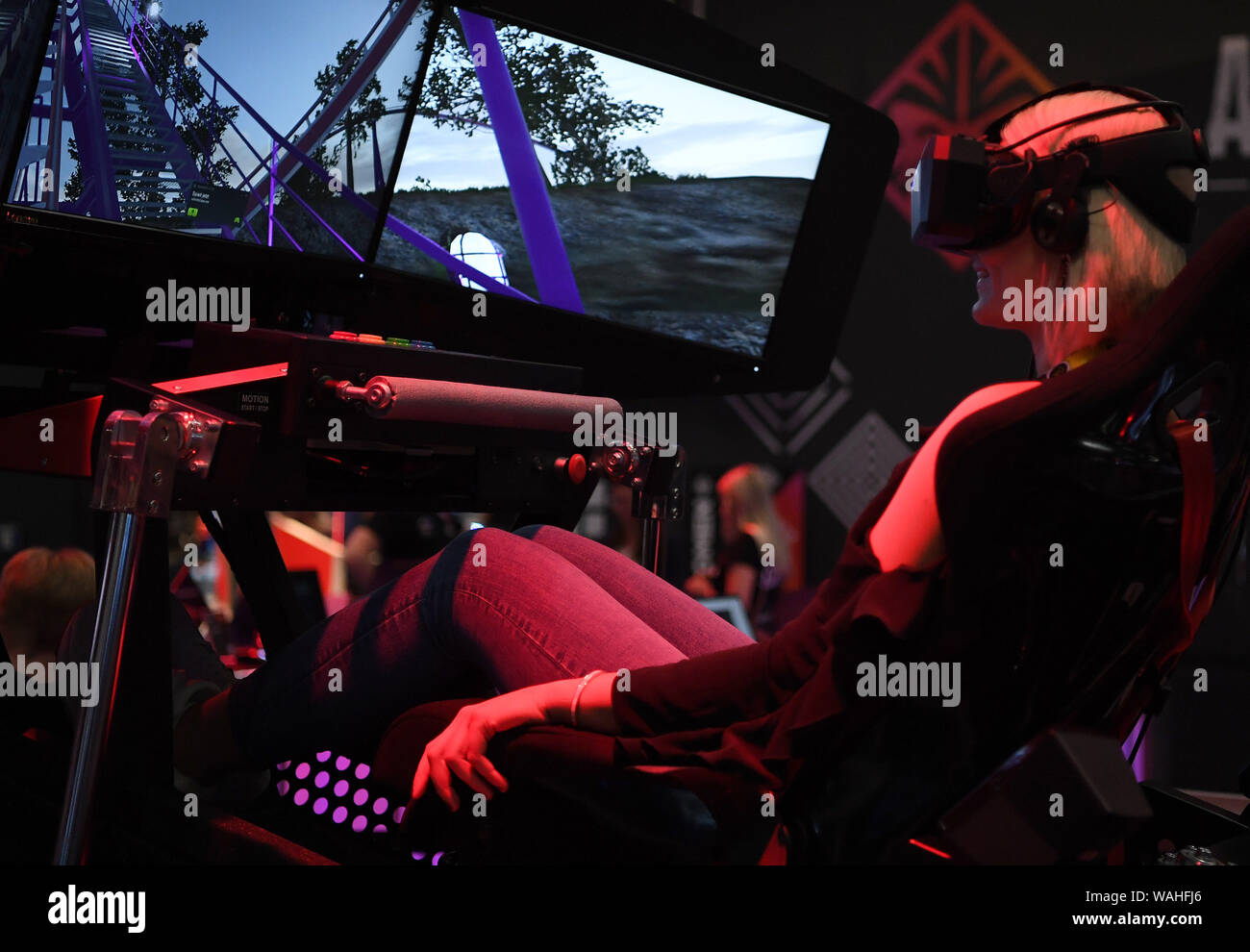 Cologne, Germany. 20th Aug, 2019. A visitor tries a VR game at the ...