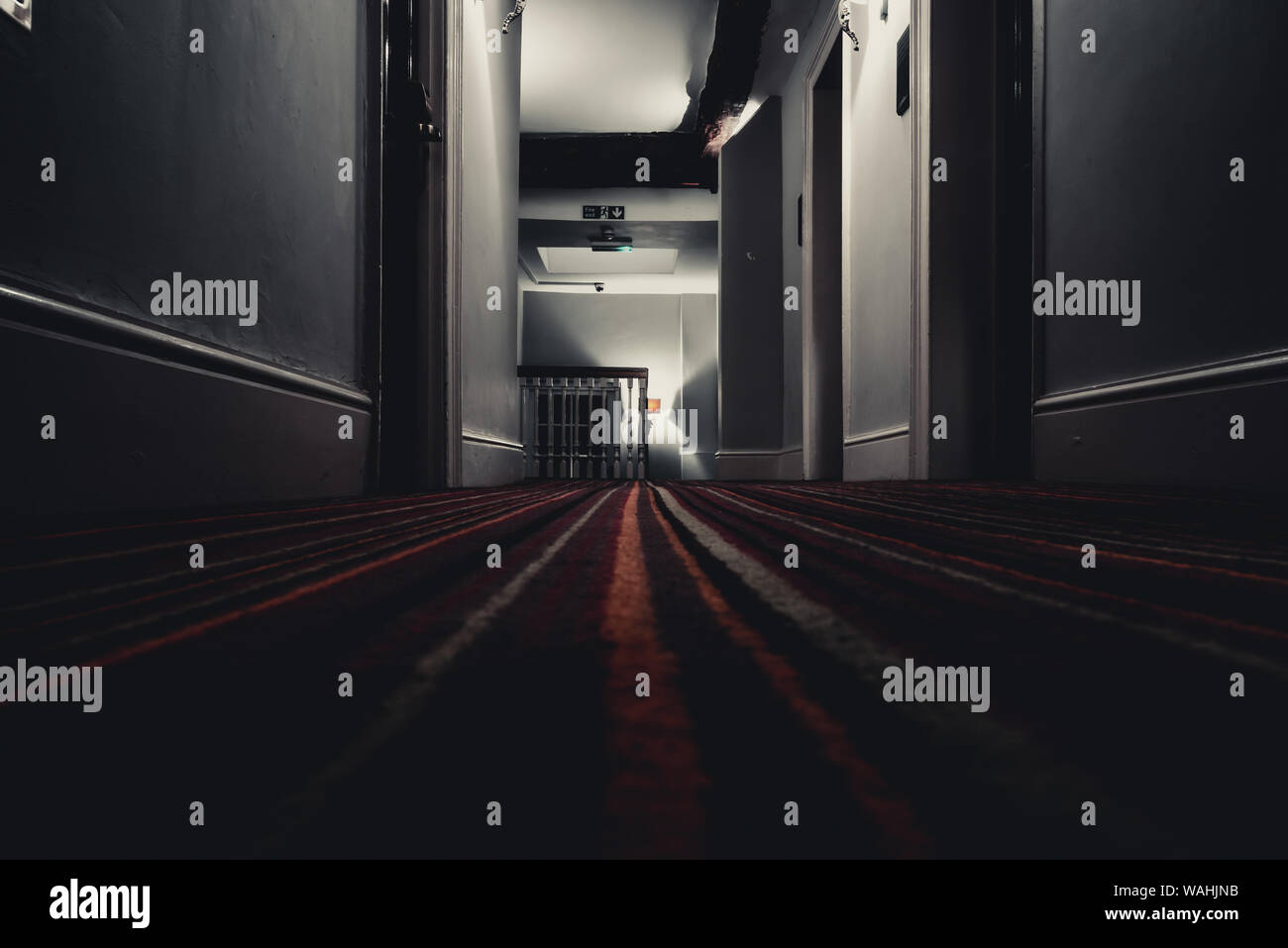 Exit fire sign hanging on ceiling on dark mysterious corridor in ...