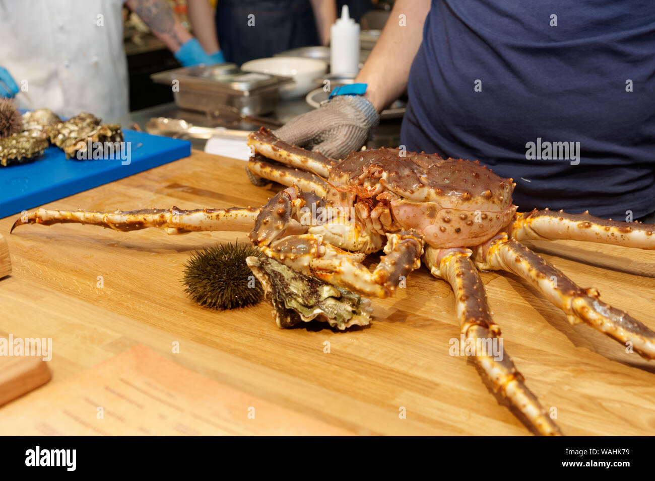 Chef is demonstrating a live crab, open restaurant kitchen Stock Photo ...