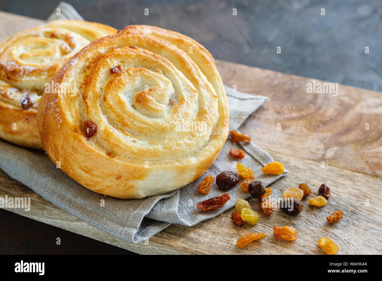 Freshly baked bun with raisins on a linen napkin Stock Photo - Alamy