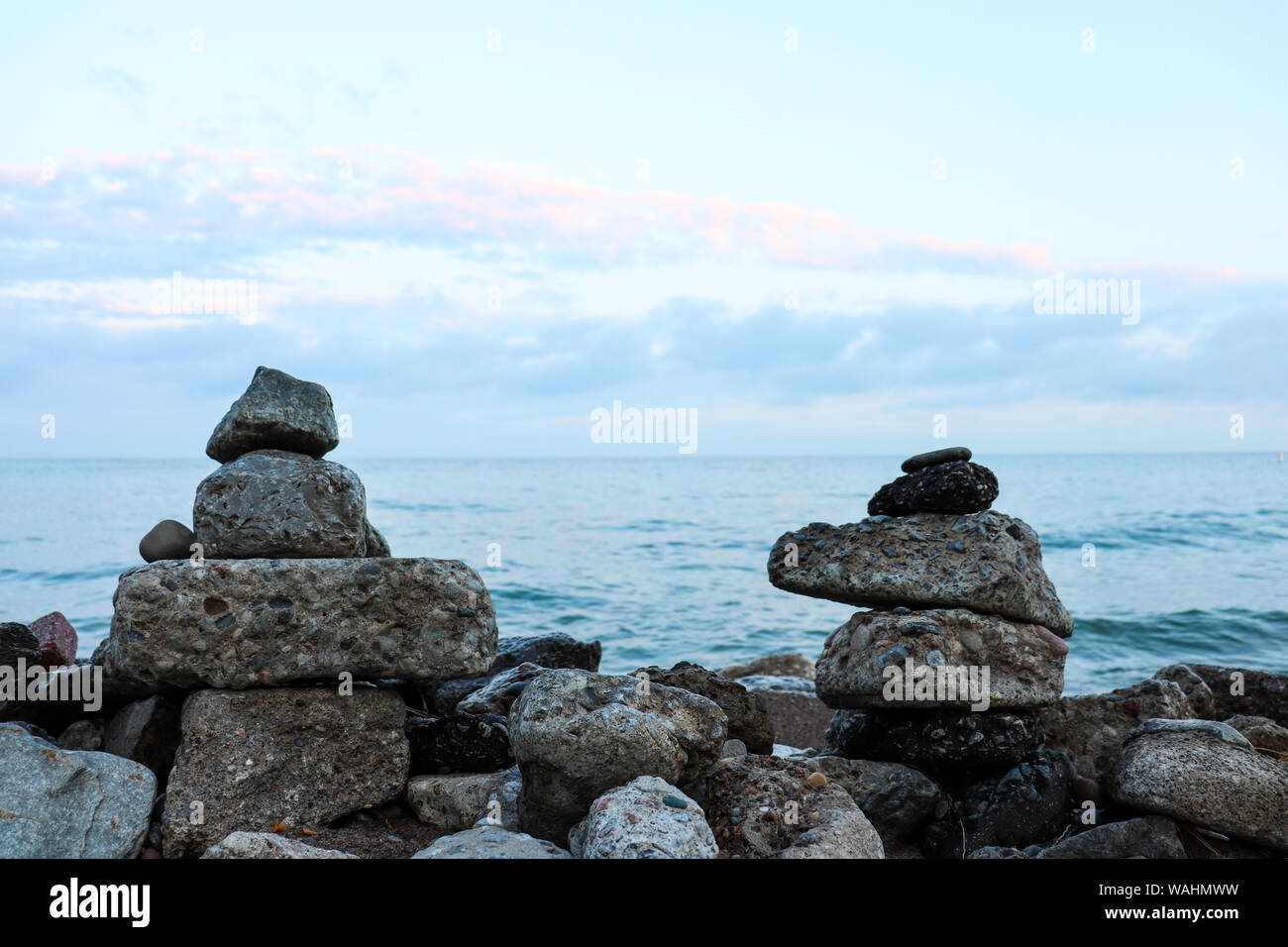 Two piles of rocks against a lakefront horizon Stock Photo - Alamy