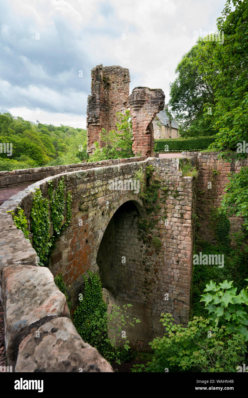 A tall brick and stone arched bridge leads to the ruins of Roslin ...