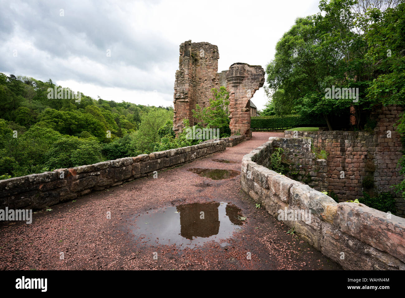 A tall brick and stone arched bridge leads to the ruins of Roslin ...