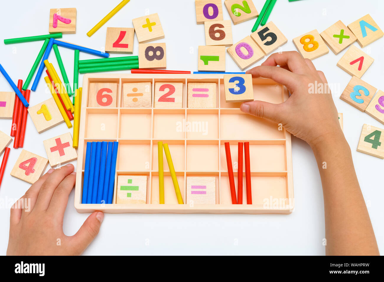 kid doing division equation using counting rods Stock Photo - Alamy