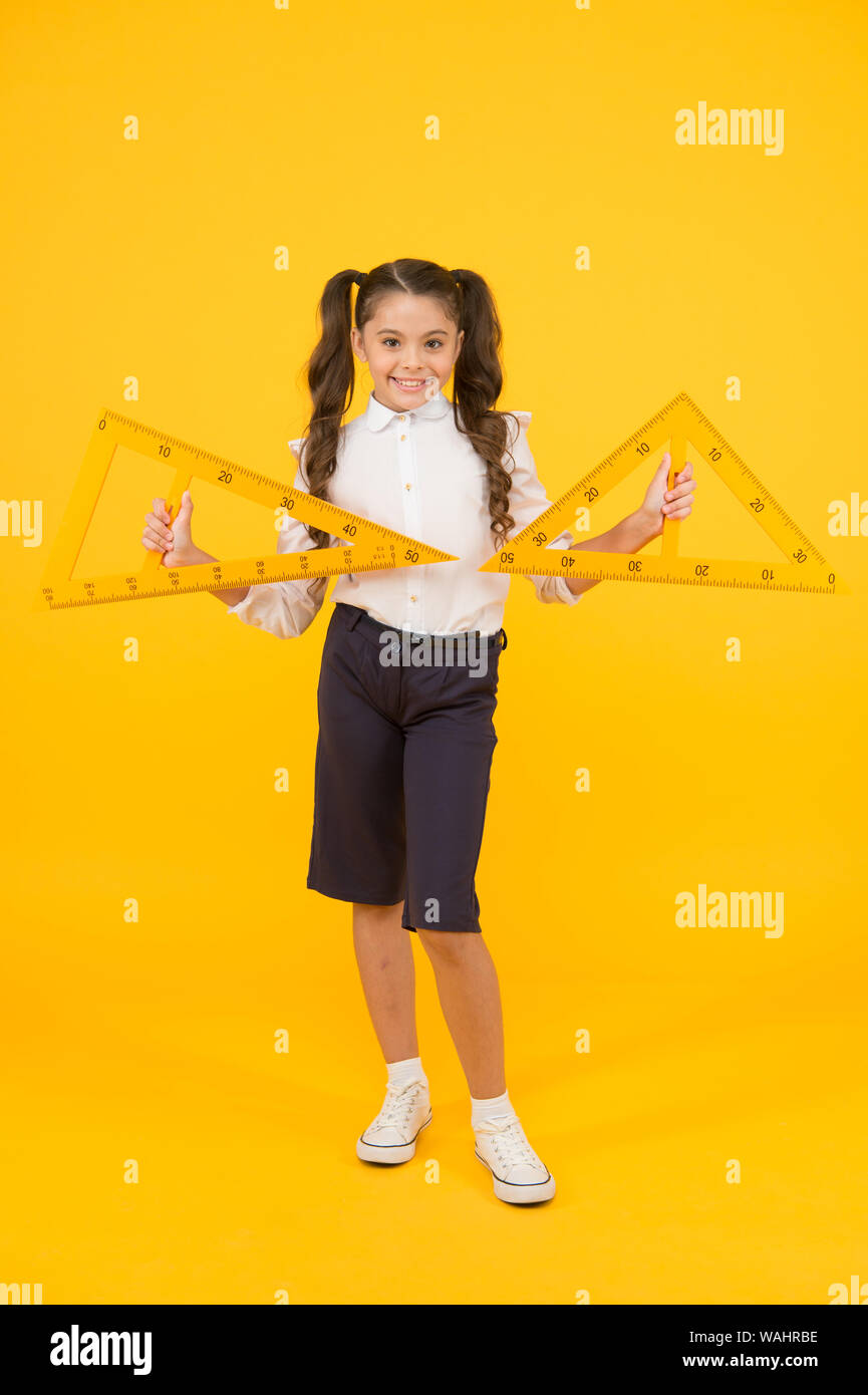 Geometry and measure. Cute schoolgirl holding triangles for geometry ...