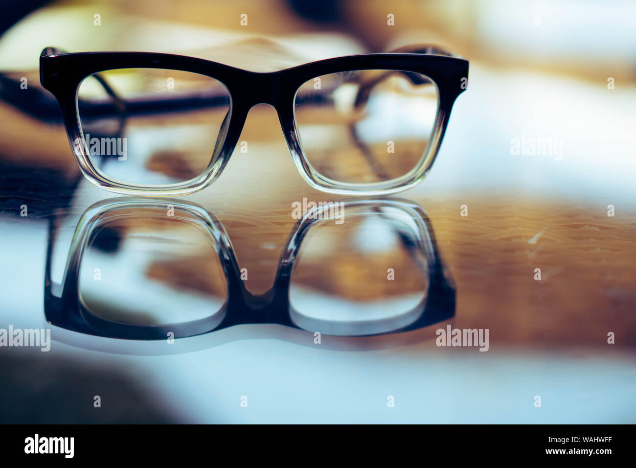 Eye glasses on wood table with reflection Stock Photo - Alamy