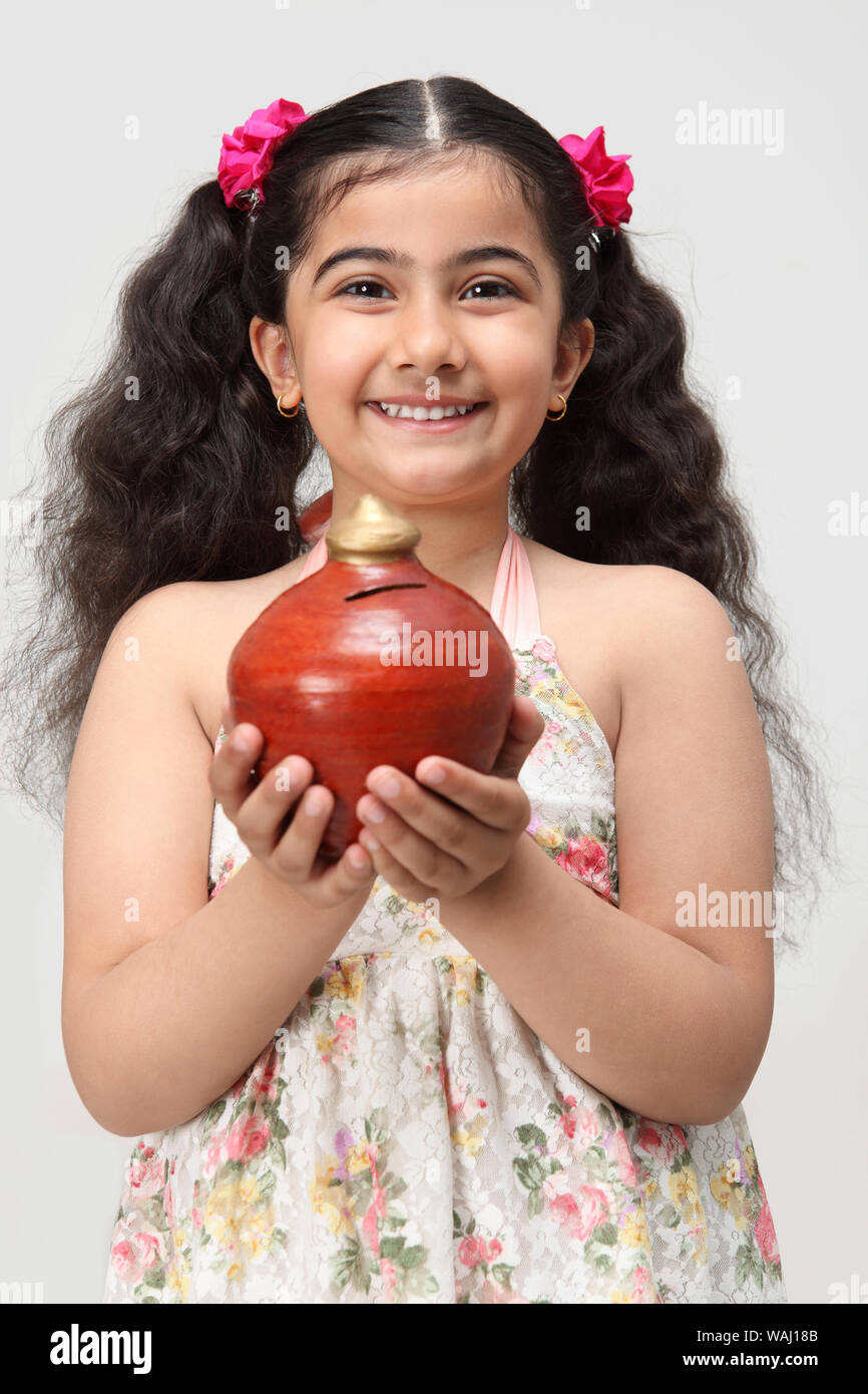 Girl holding a piggy bank and smiling Stock Photo - Alamy Girl holding a piggy bank and smiling Stock Photo - Alamy