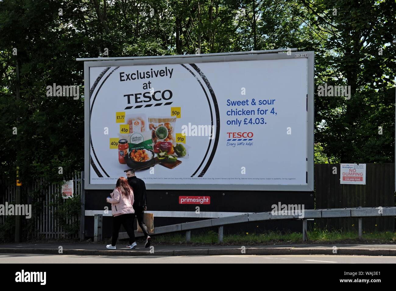 People walking past a Tesco advertising billboard on King's Road ...
