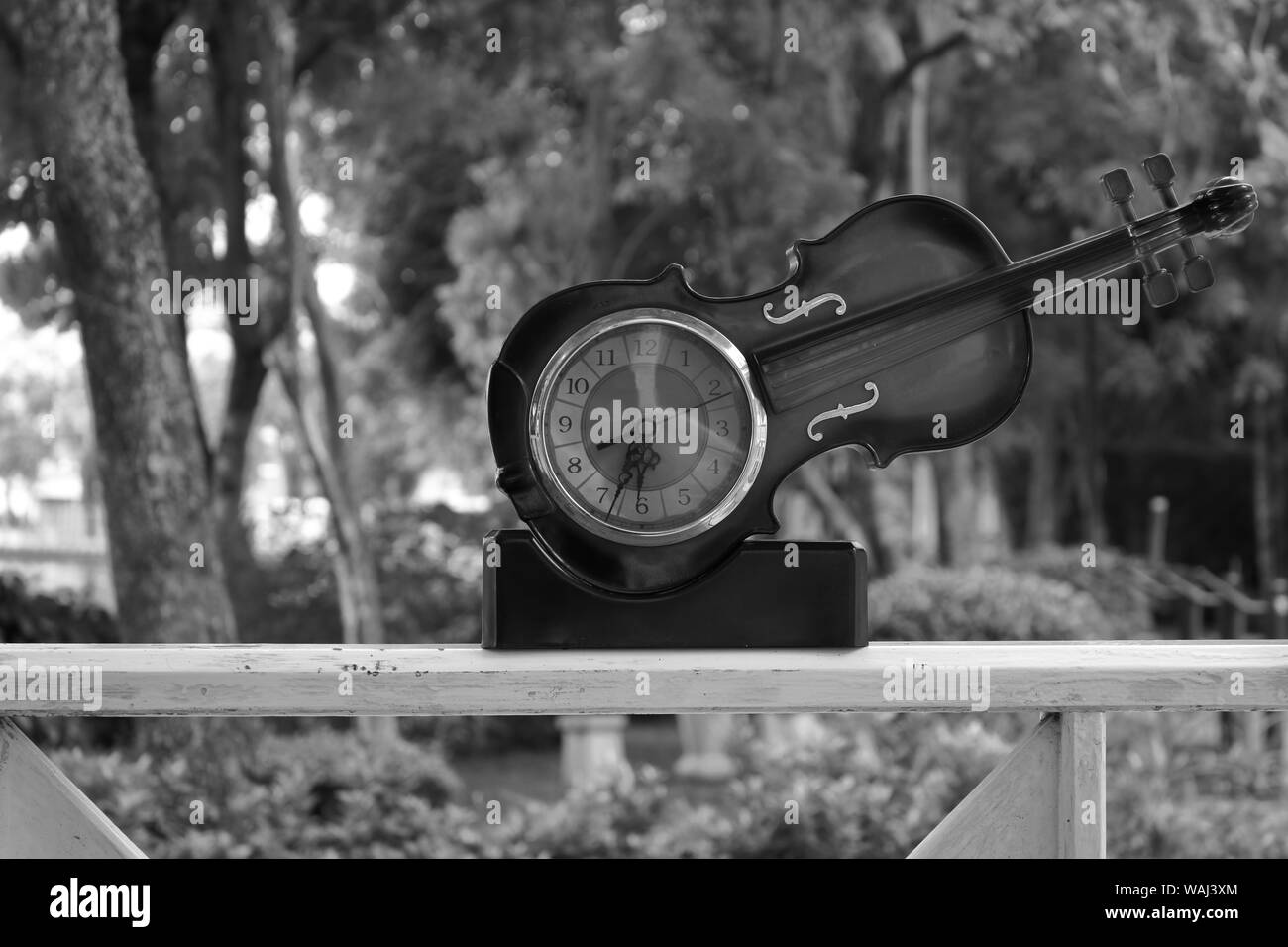 Closeup clock face of vintage violin shape clock, black and white ...