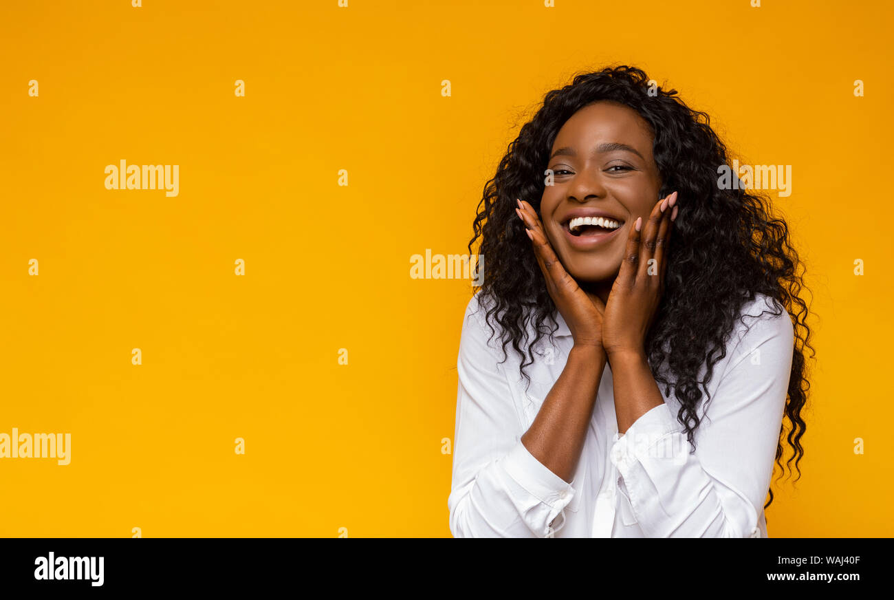 Pretty african american girl laughing and touching her cheeks Stock ...