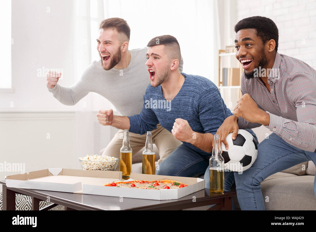 Football fans watching match and cheering for favourite team Stock ...