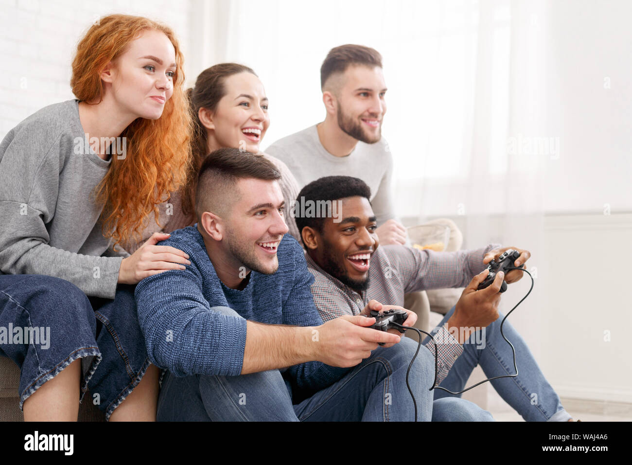 Group of friends having fun, playing video games Stock Photo - Alamy