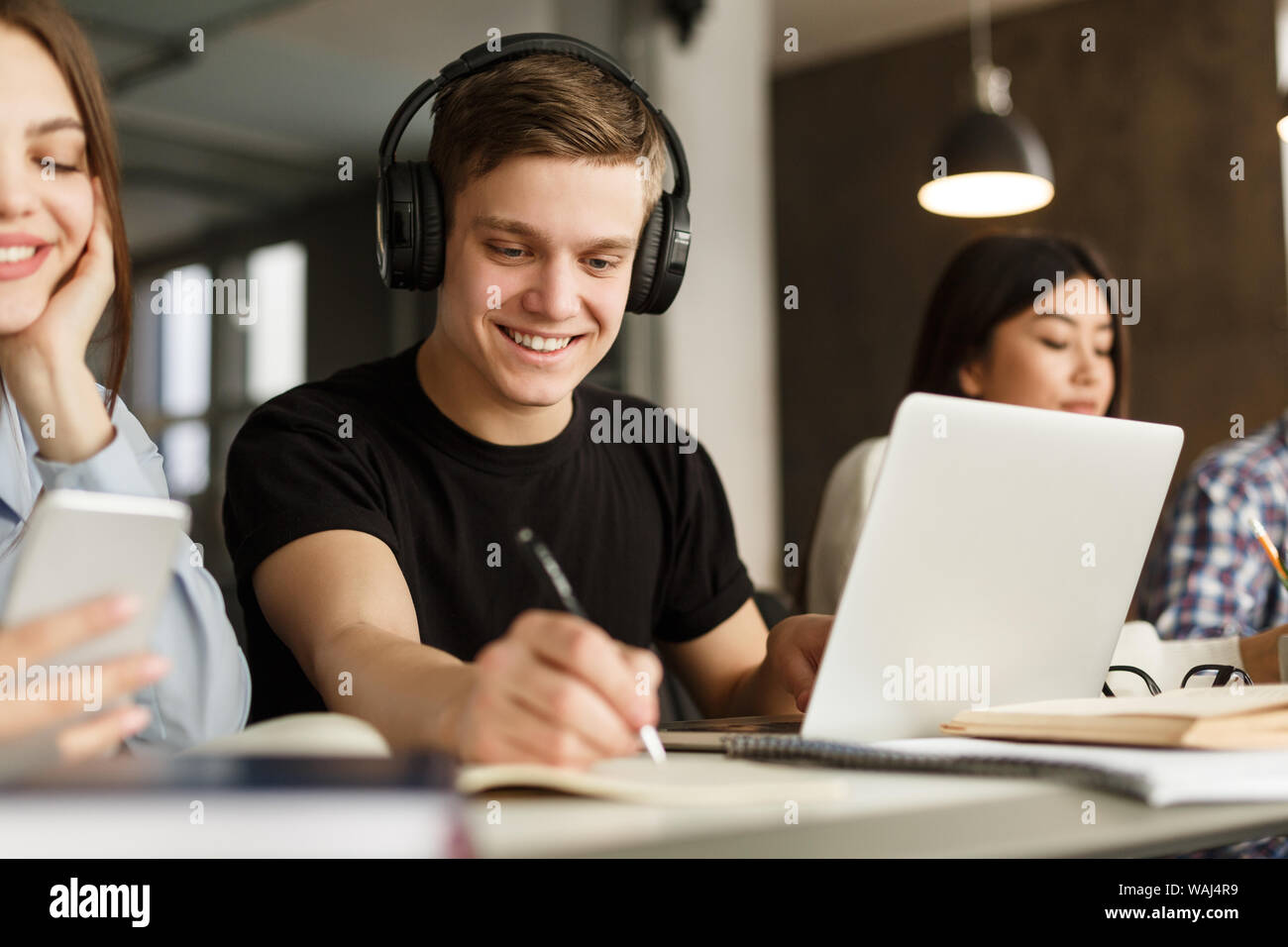 College student taking notes, doing assignments in library Stock Photo ...