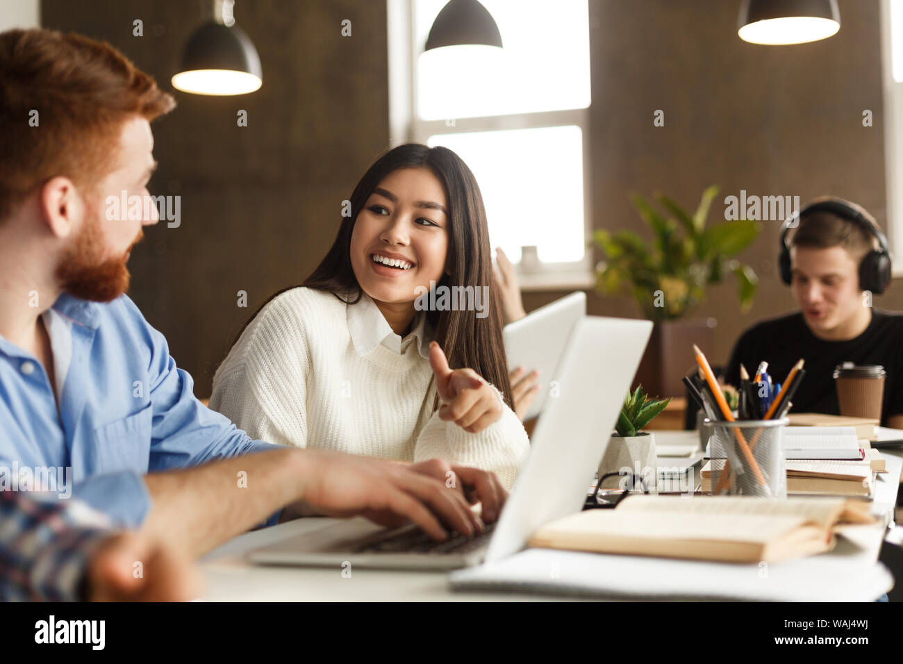 Cheerful college friends talking, preparing for exams together Stock ...