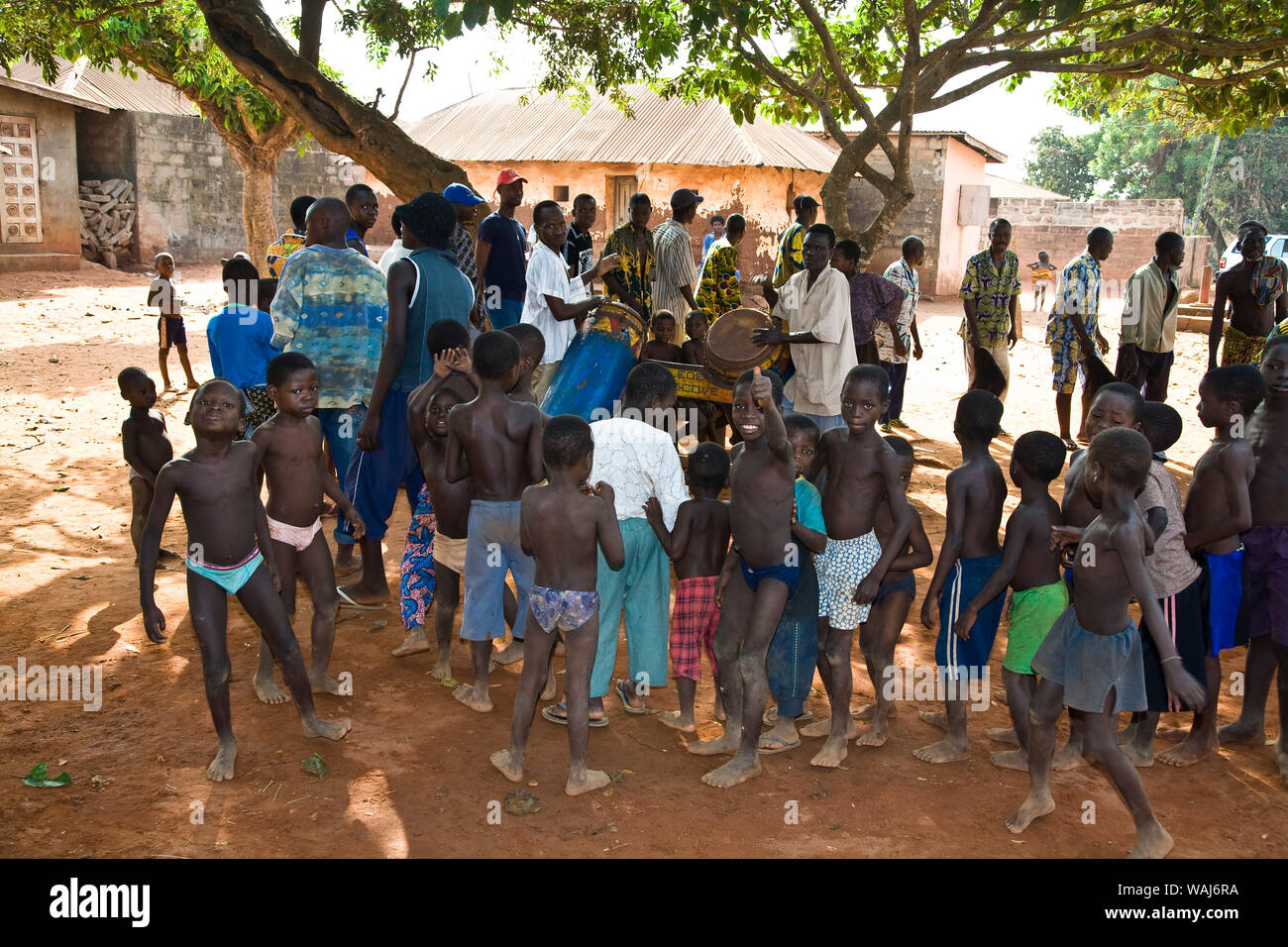 West Africa, Benin. Men and children gathered around drum circle before ...