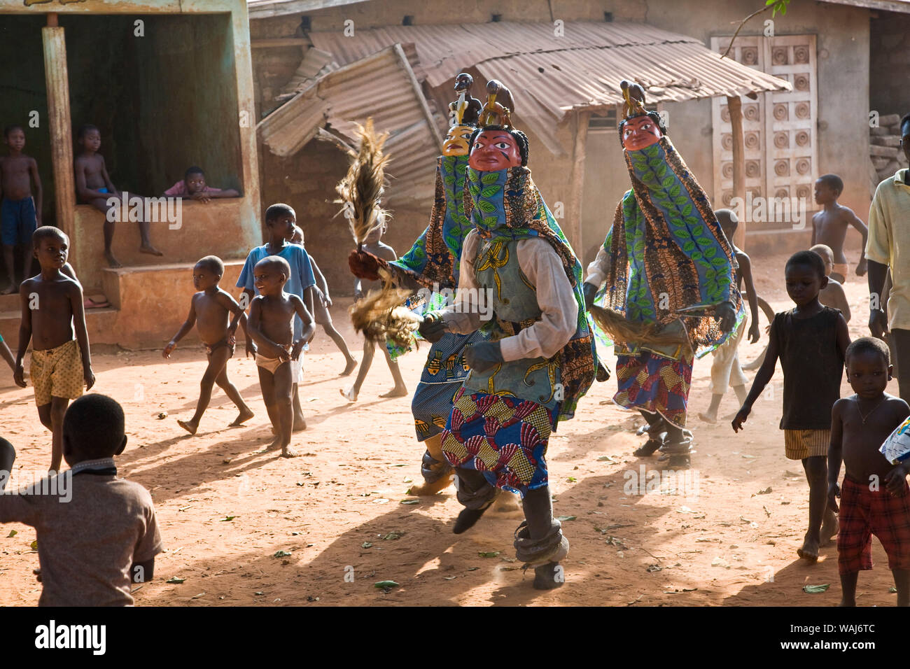 West Africa, Benin. Gelede Mask Dancers perform as children watch Stock ...