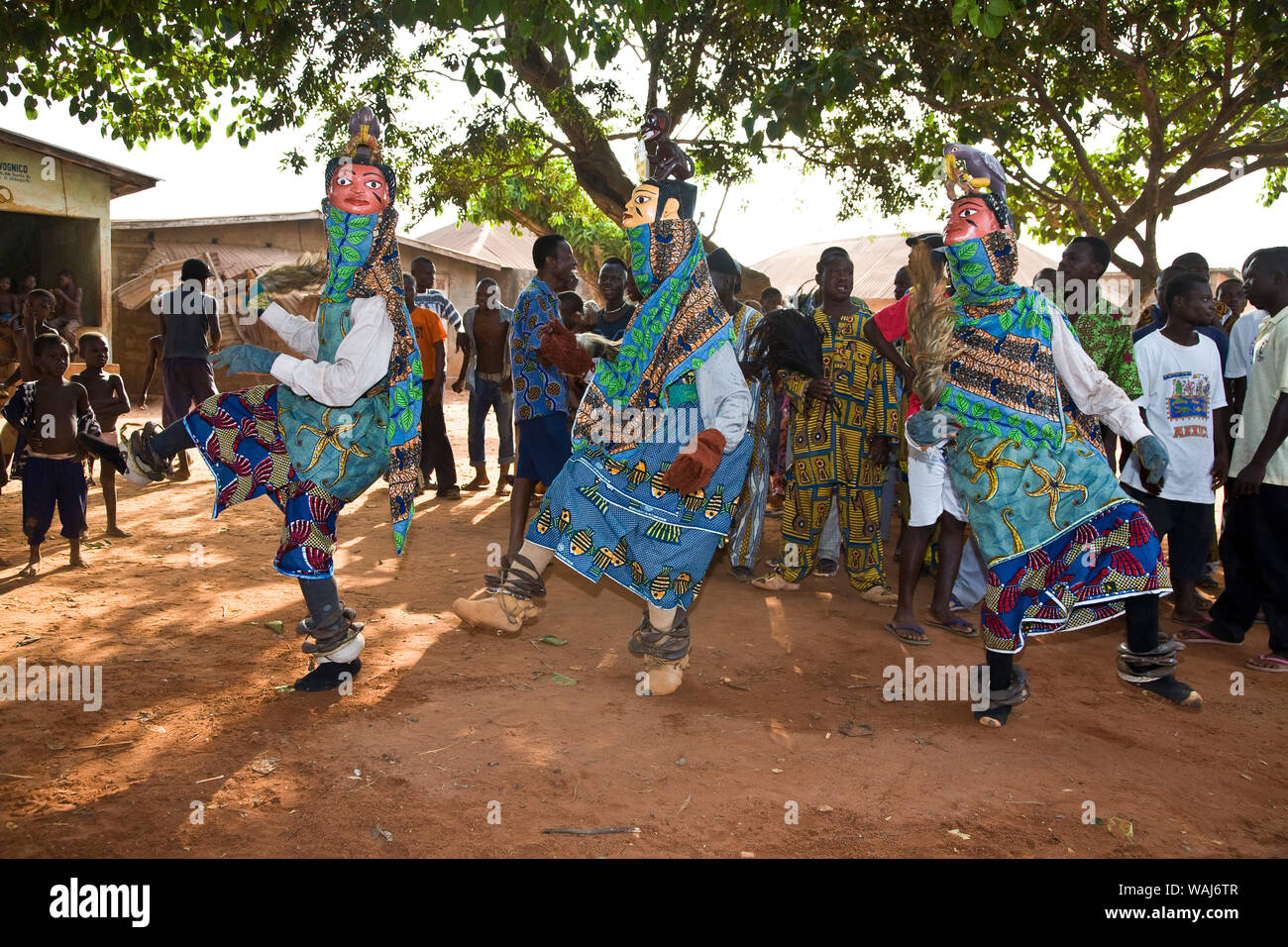 West Africa, Benin. Men and children watch Gelede Mask Dancers perform ...