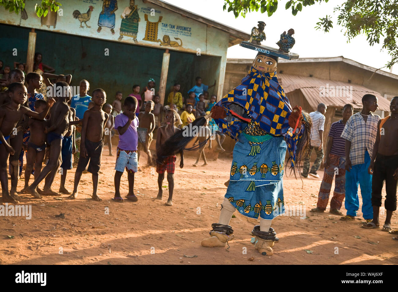 West Africa, Benin. Men and children watch Gelede Mask Dancers perform ...